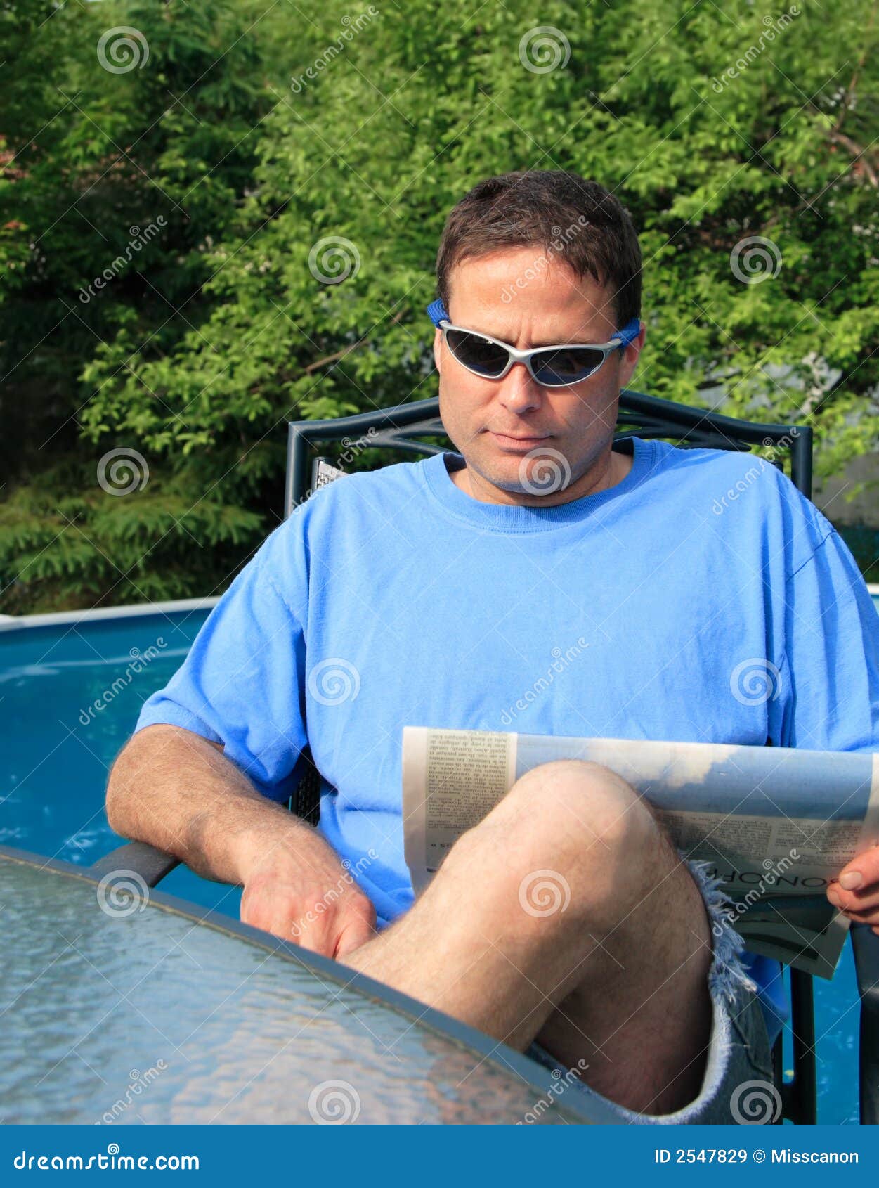 Man reading near a pool stock image. Image of casual, appealing - 2547829