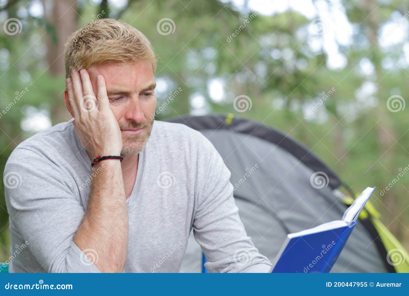 Man reading outside tent stock image. Image of reflection - 200447955