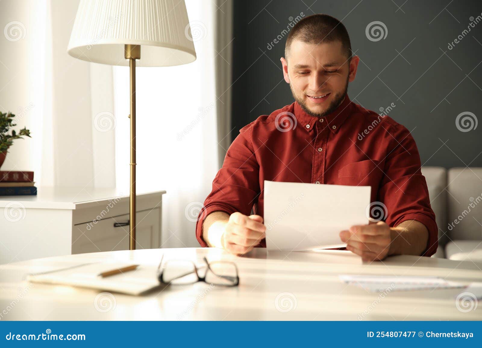 Man Reading Paper Letter at White Table in Room Stock Image - Image of ...