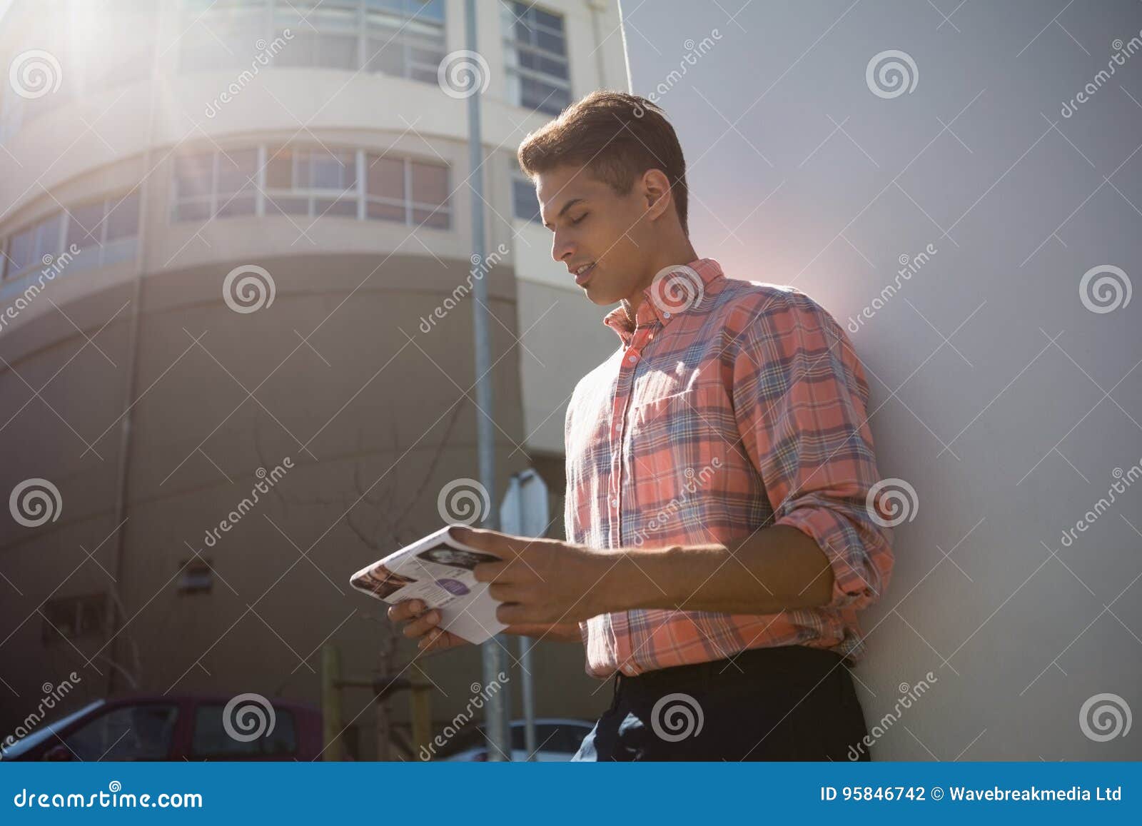 Man Reading Paper while Standing by Wall Stock Photo - Image of life ...