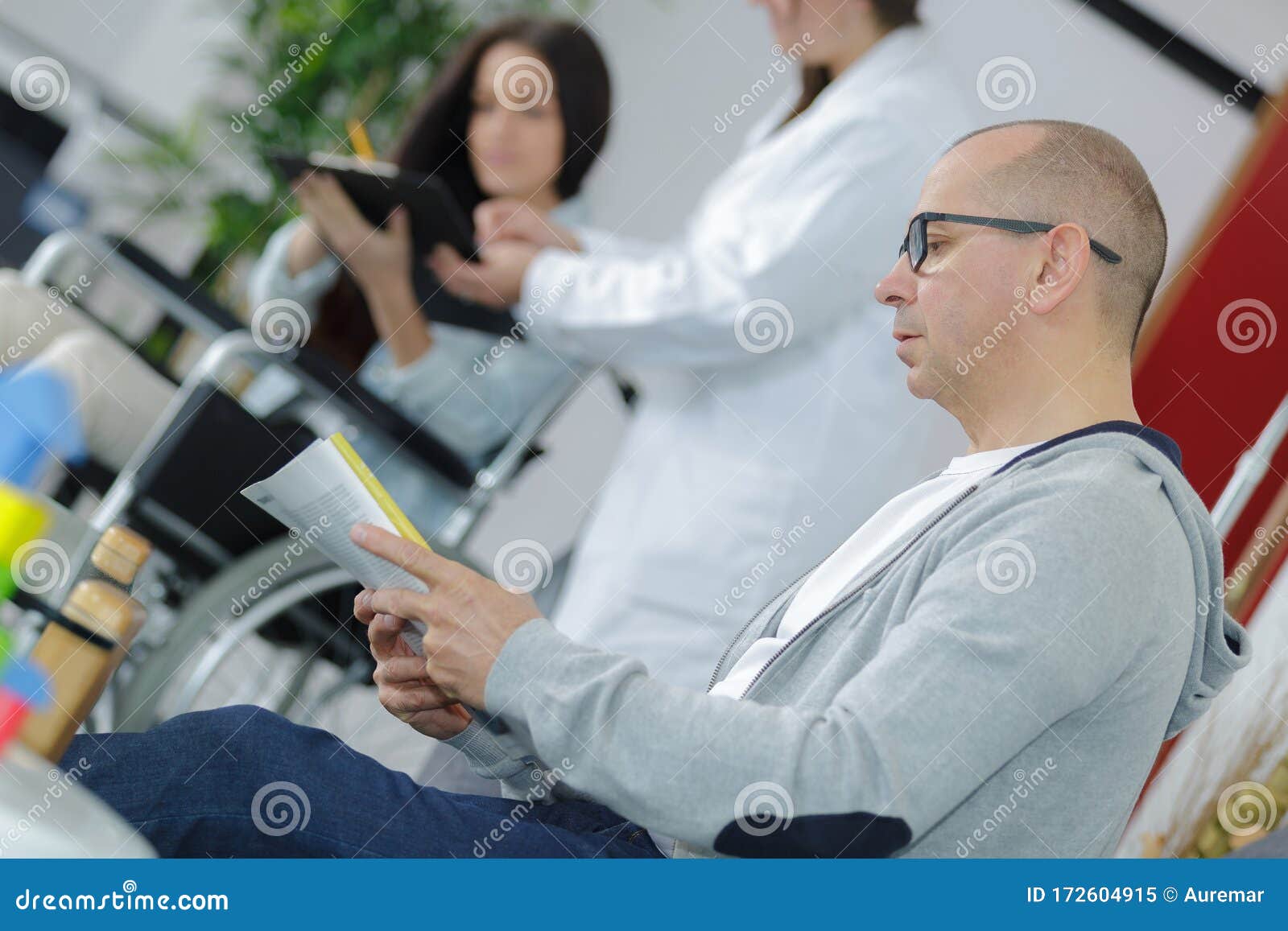 Man Reading Papers in Medical Waiting Room Stock Image - Image of ...