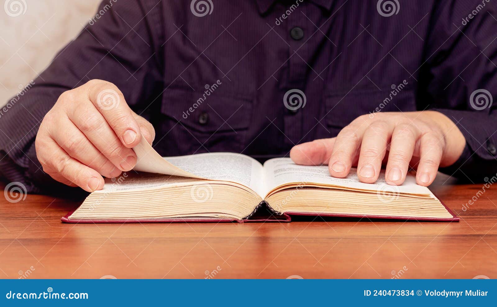 A Man Reads the Bible while Sitting at a Table. an Open Book in the ...
