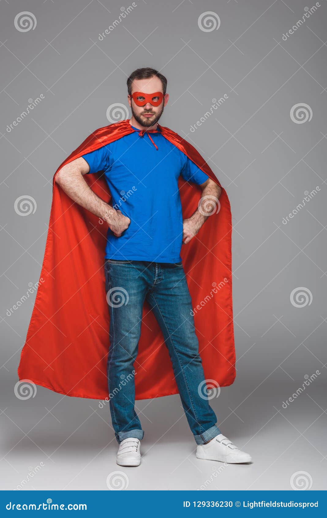 Man in Red Cloak and Mask Standing with Hands on Waist and Looking at ...