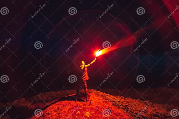 The Man with a Red Firework Stick Standing on a Night Mountain. Stock ...