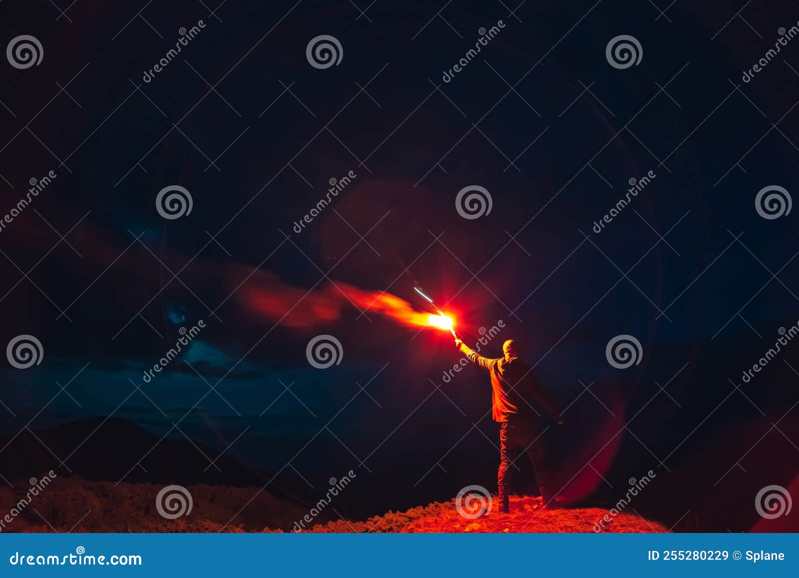 The Man with a Red Firework Stick Standing on a Night Mountain. Stock ...