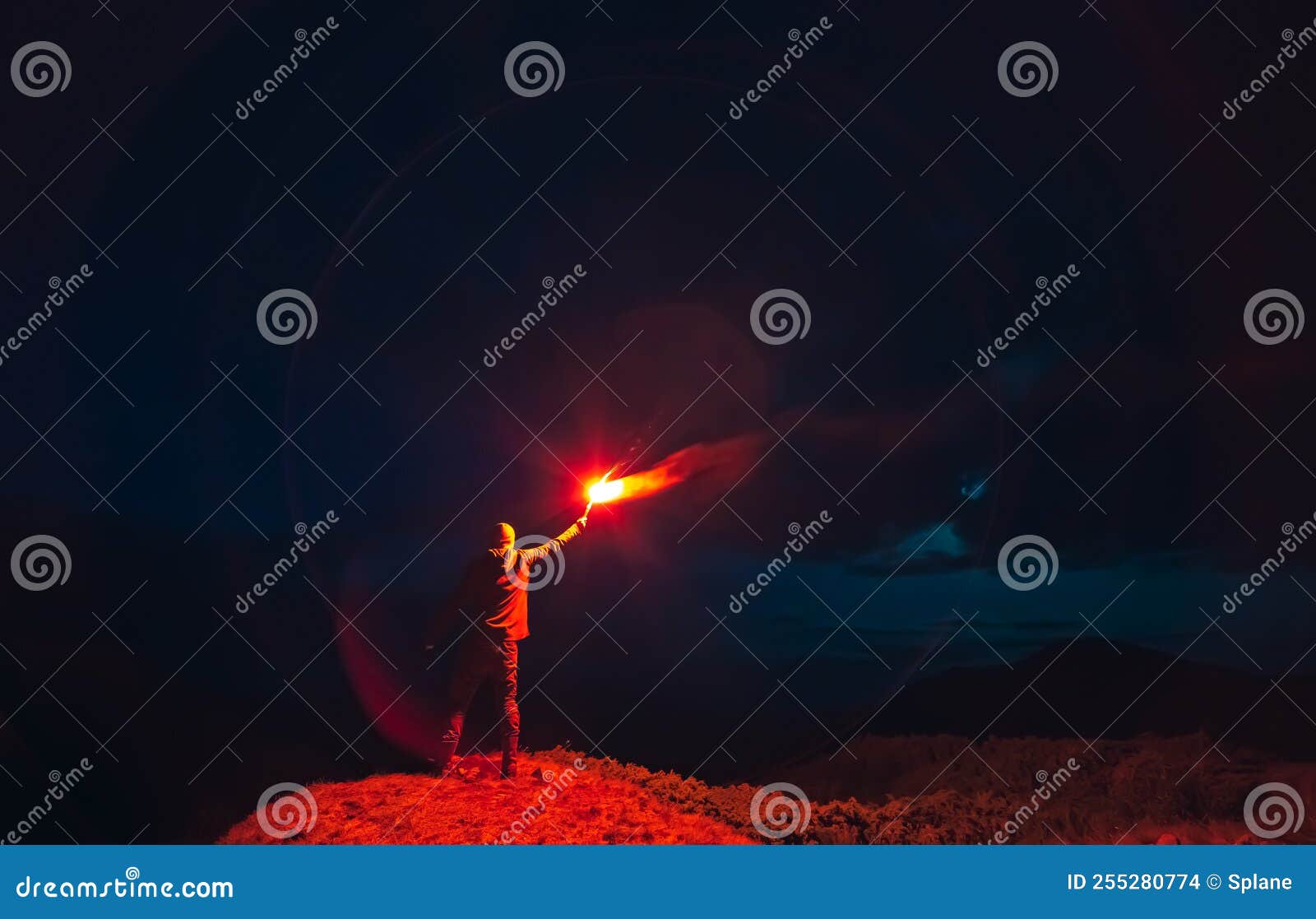 The Man with a Red Firework Stick Standing on a Night Mountain. Stock ...
