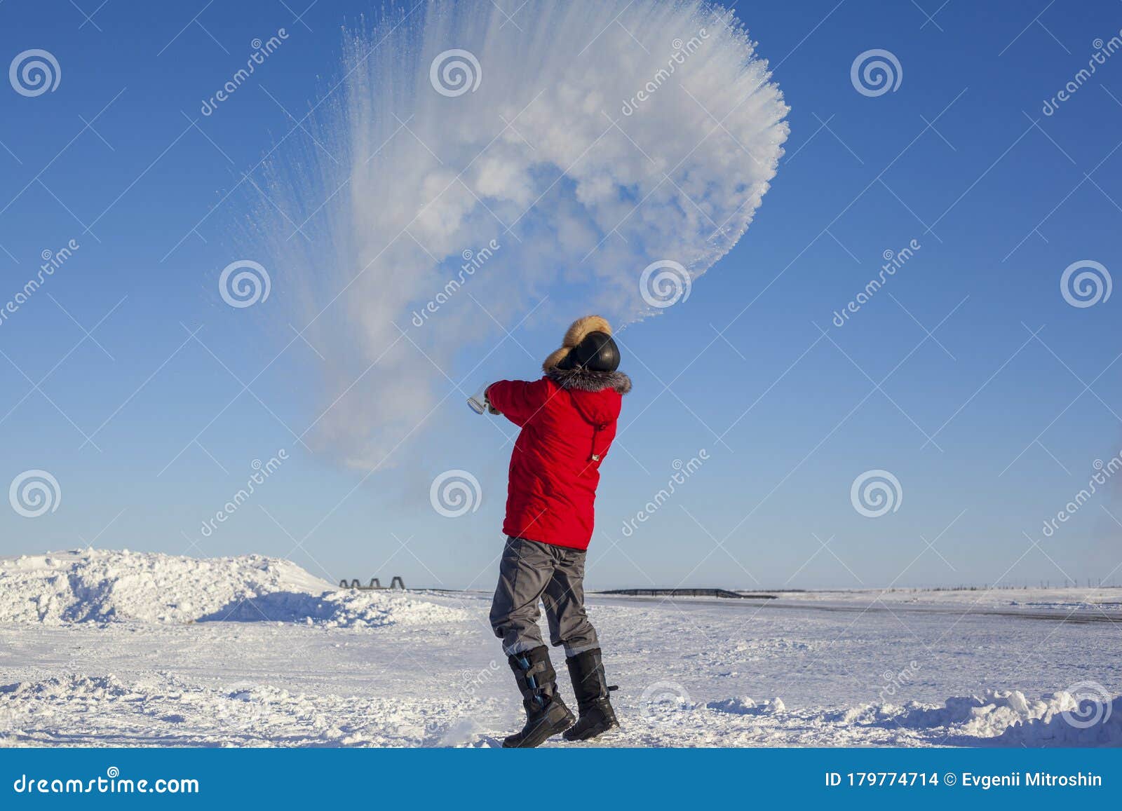 A Man in a Red Jacket Throws a Bottle of Boiling Water into the Air ...
