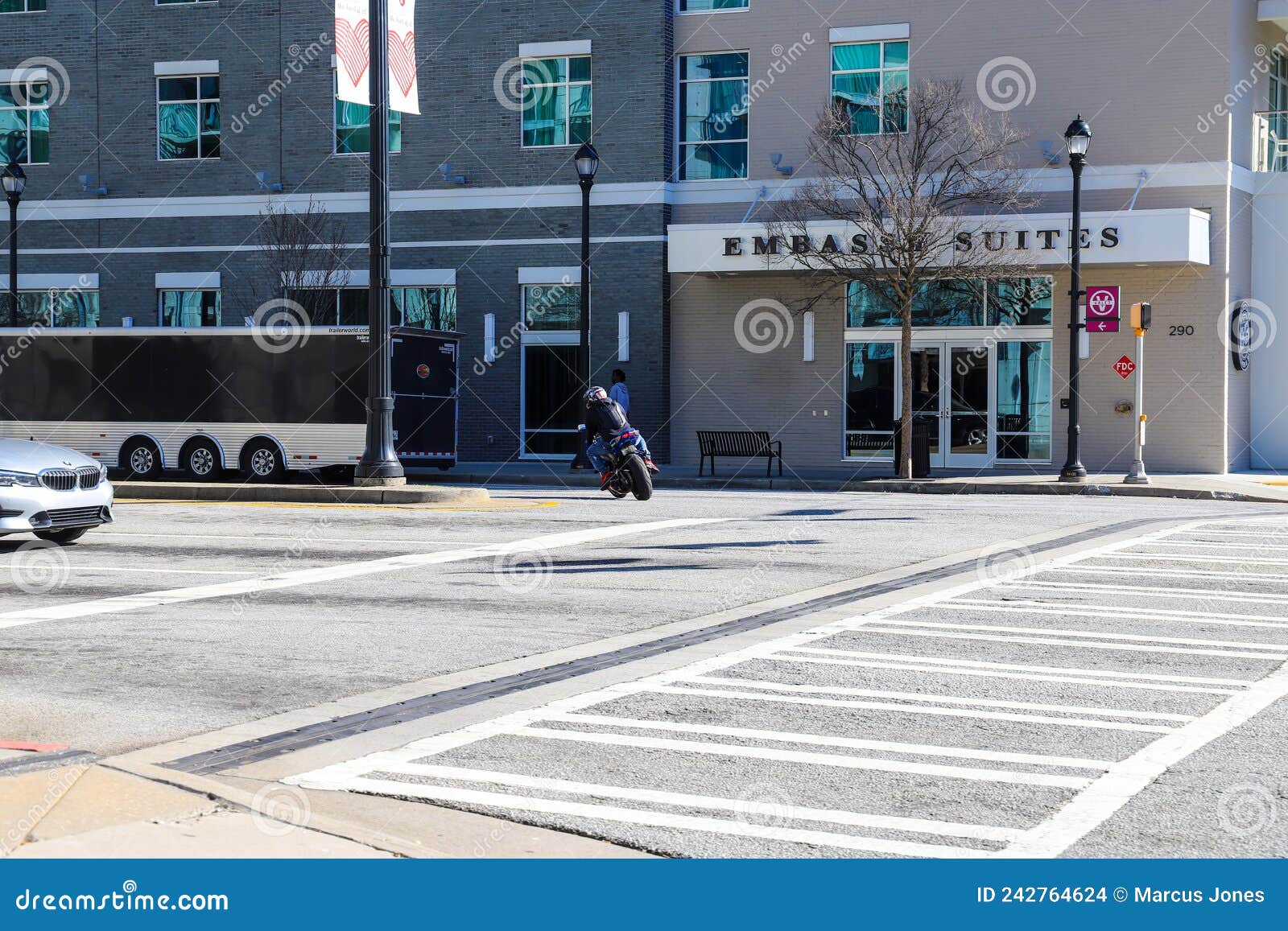 A Man on a Red Motorcycle Making a Turn at an Intersection Surrounded ...