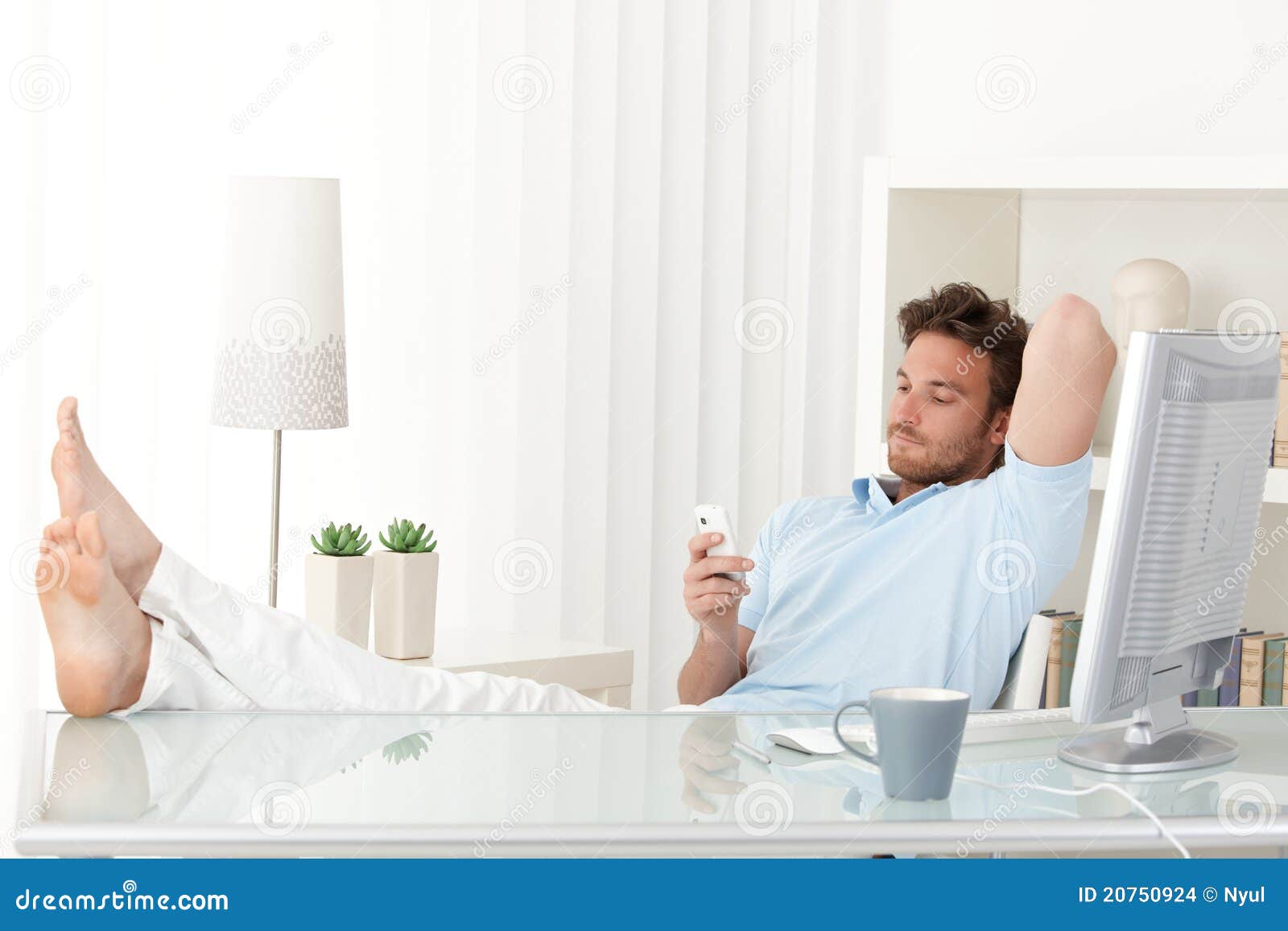 Man Relaxing at Desk, Texting on Phone Stock Photo - Image of american ...