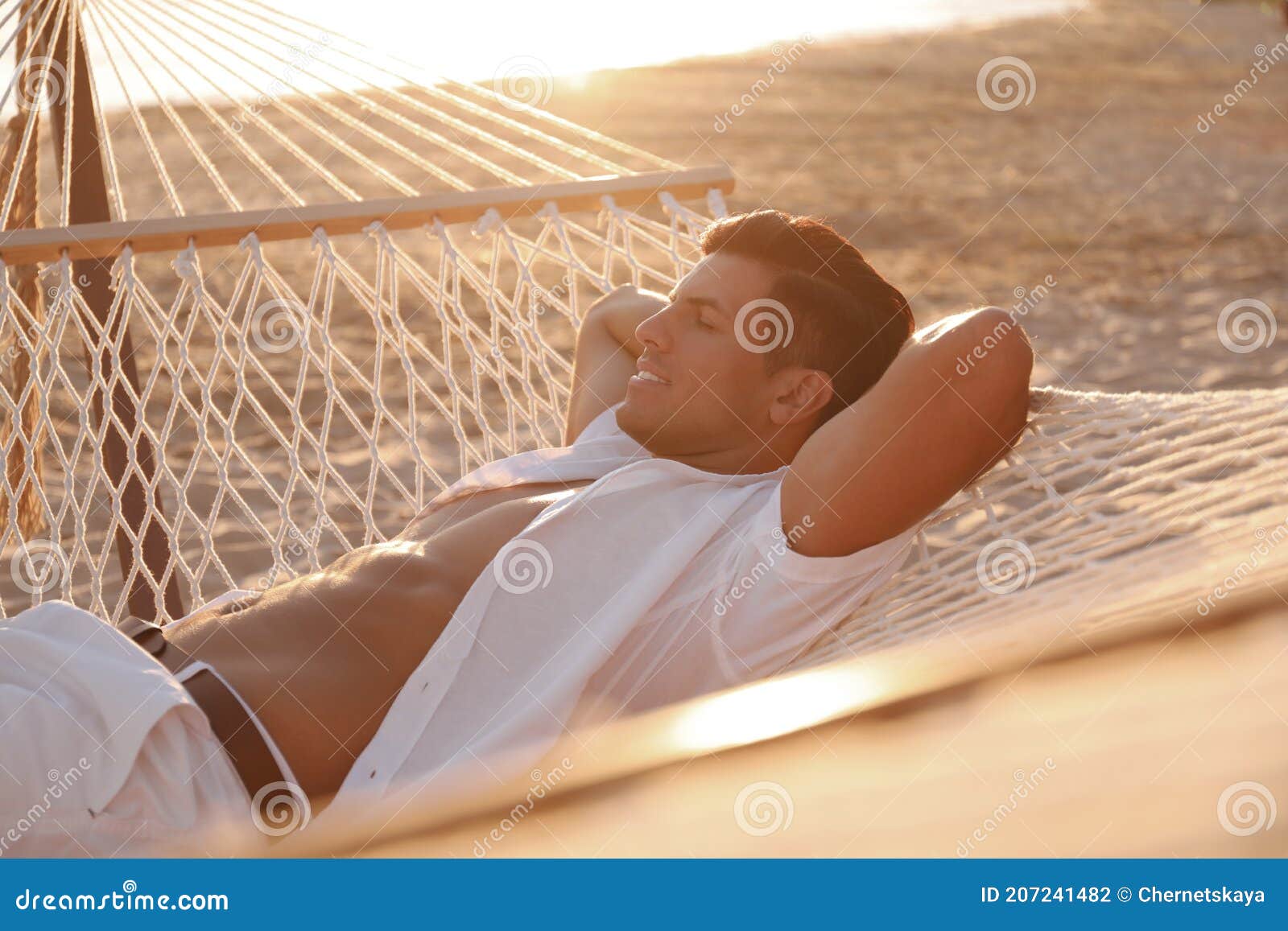 Man Relaxing in Hammock on Beach at Sunset Stock Photo - Image of ...