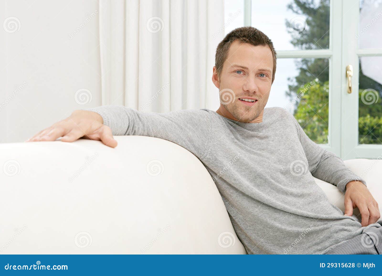 Man Relaxing on Sofa at Home. Stock Photo - Image of property, couch ...