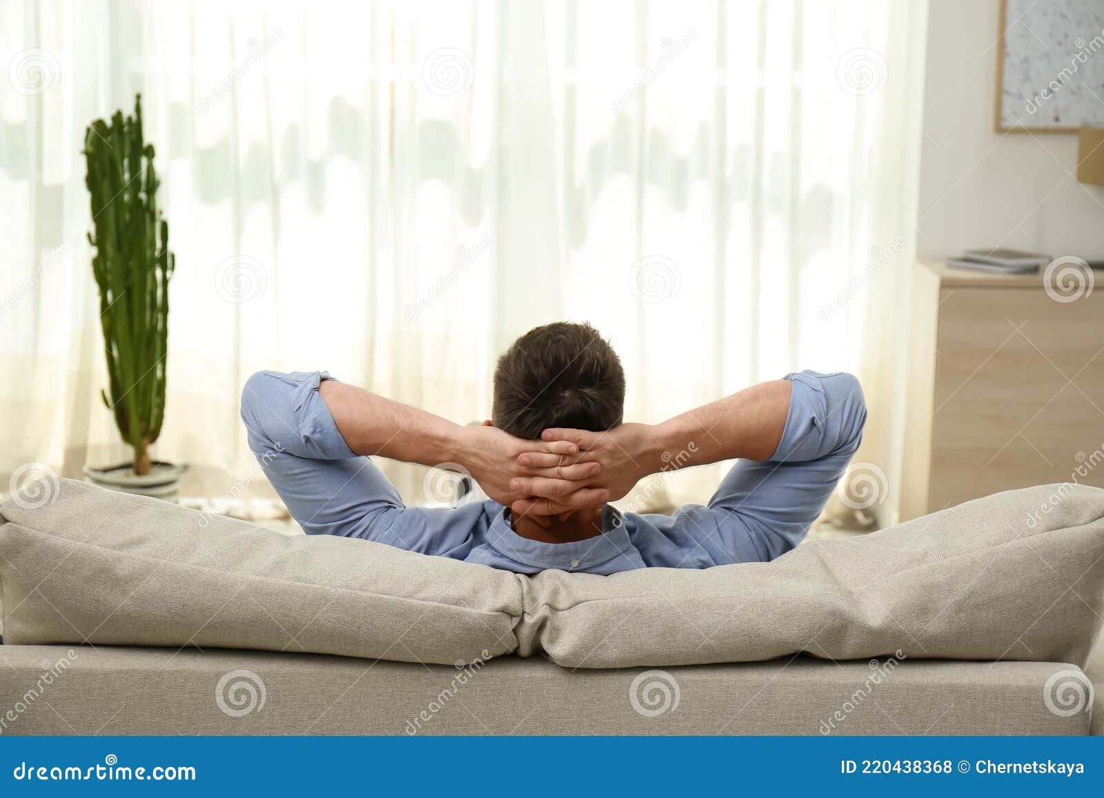 Man Relaxing on Sofa at Home Stock Photo - Image of atmosphere, home ...