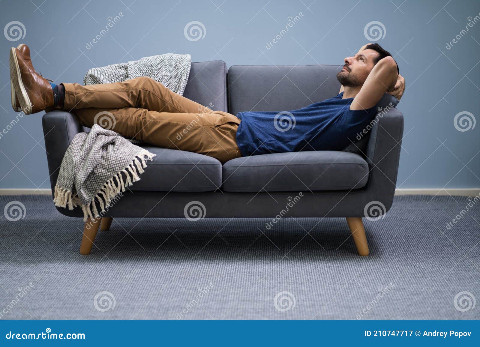 Man Relaxing on Sofa at Home Stock Image - Image of calm, closed: 210747717