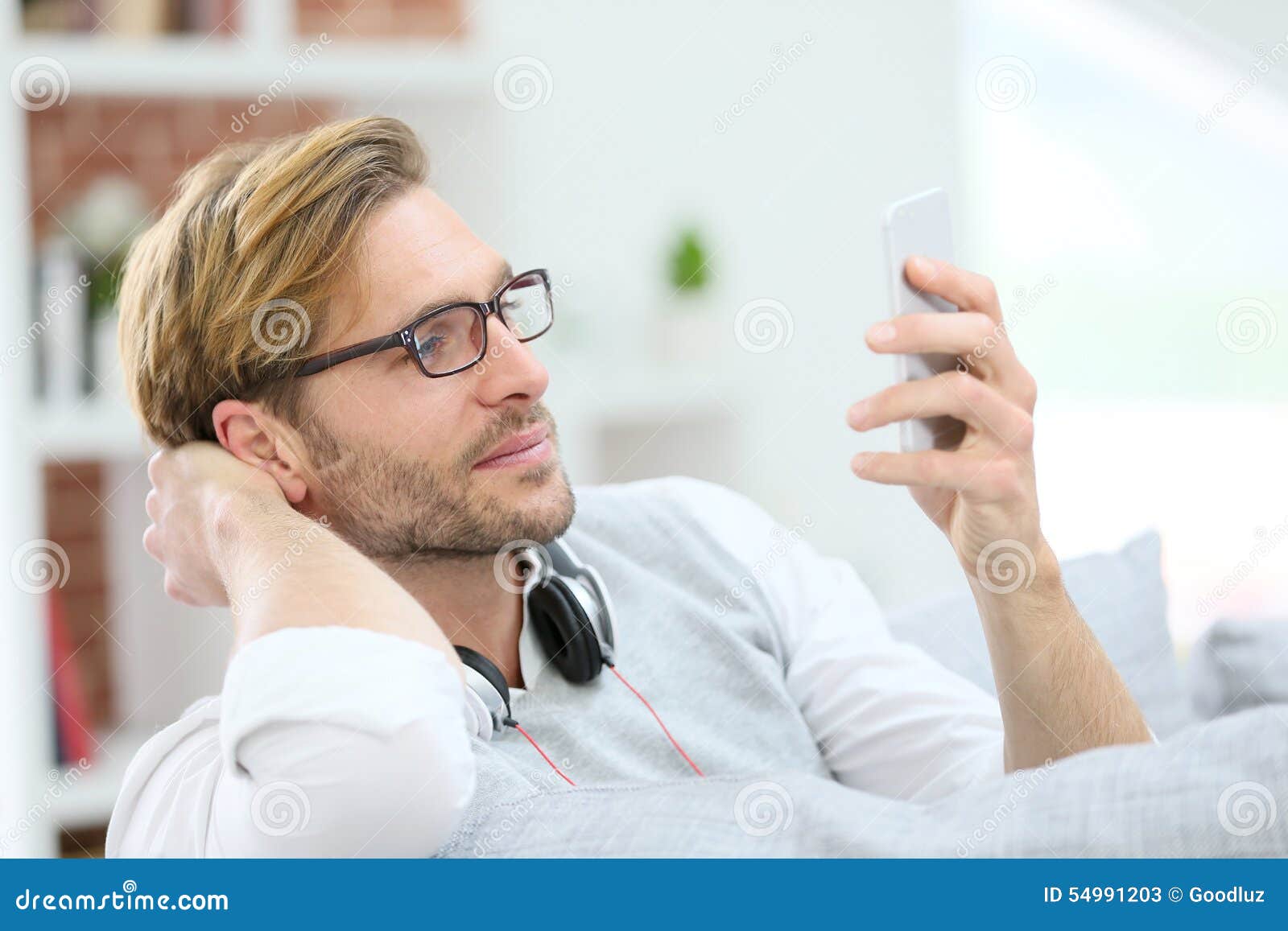 Man Relaxing in Sofa Using Smartphone Stock Image - Image of headphones ...
