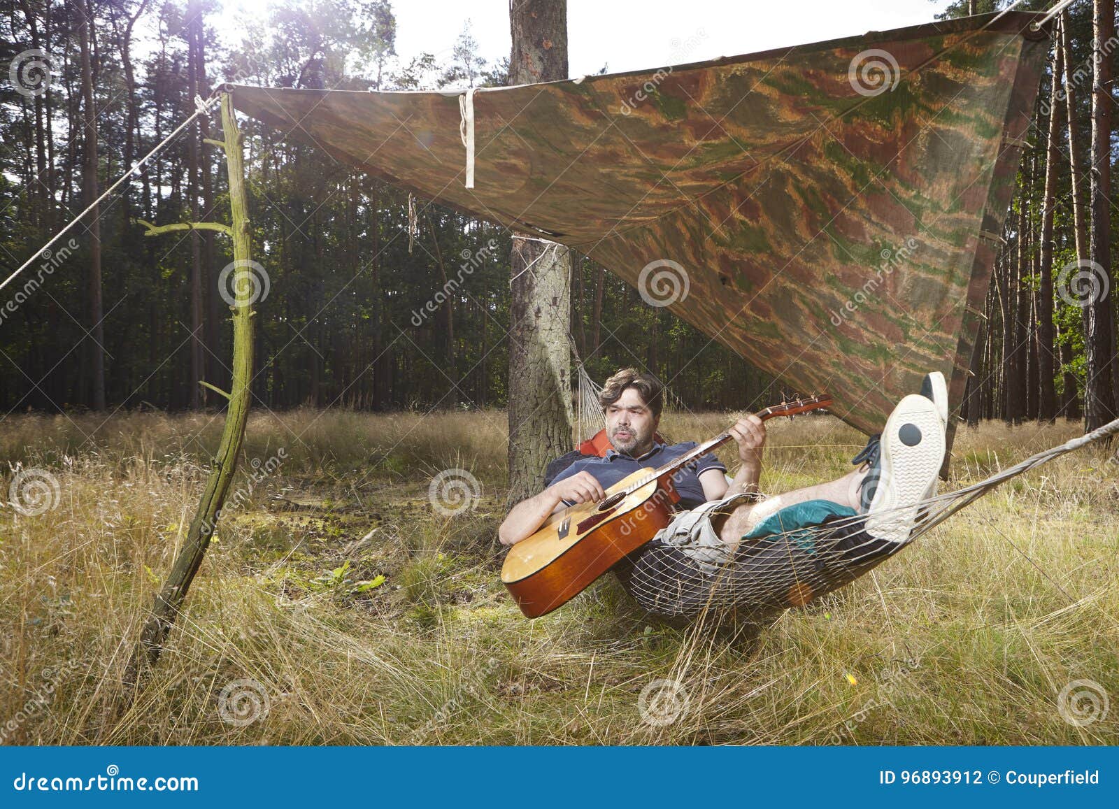 Man Relaxing in Wilderness with Guitar in Hammock Stock Photo - Image ...