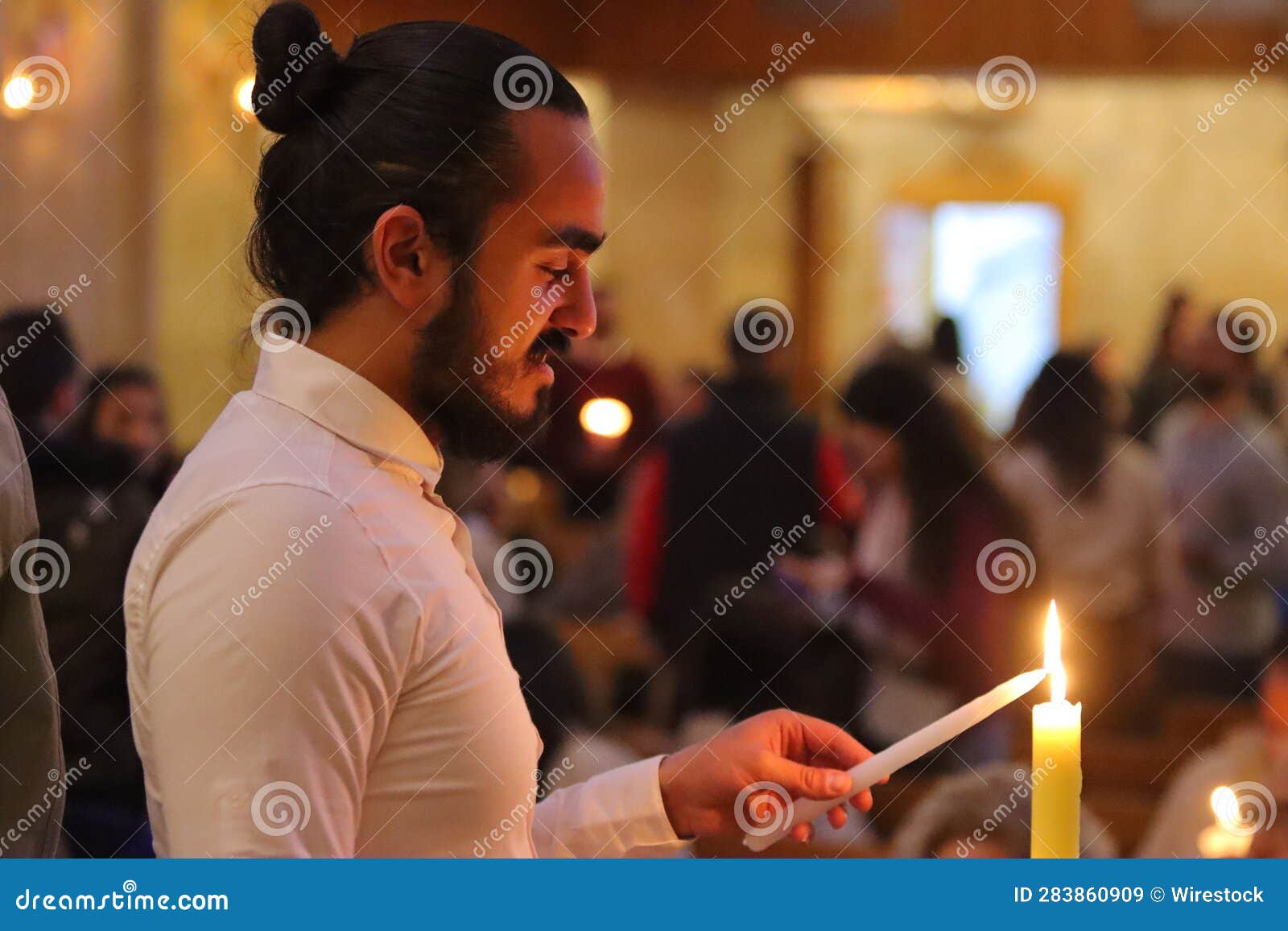 Man in a Religious Setting Participating in a Ceremony by Lighting a ...