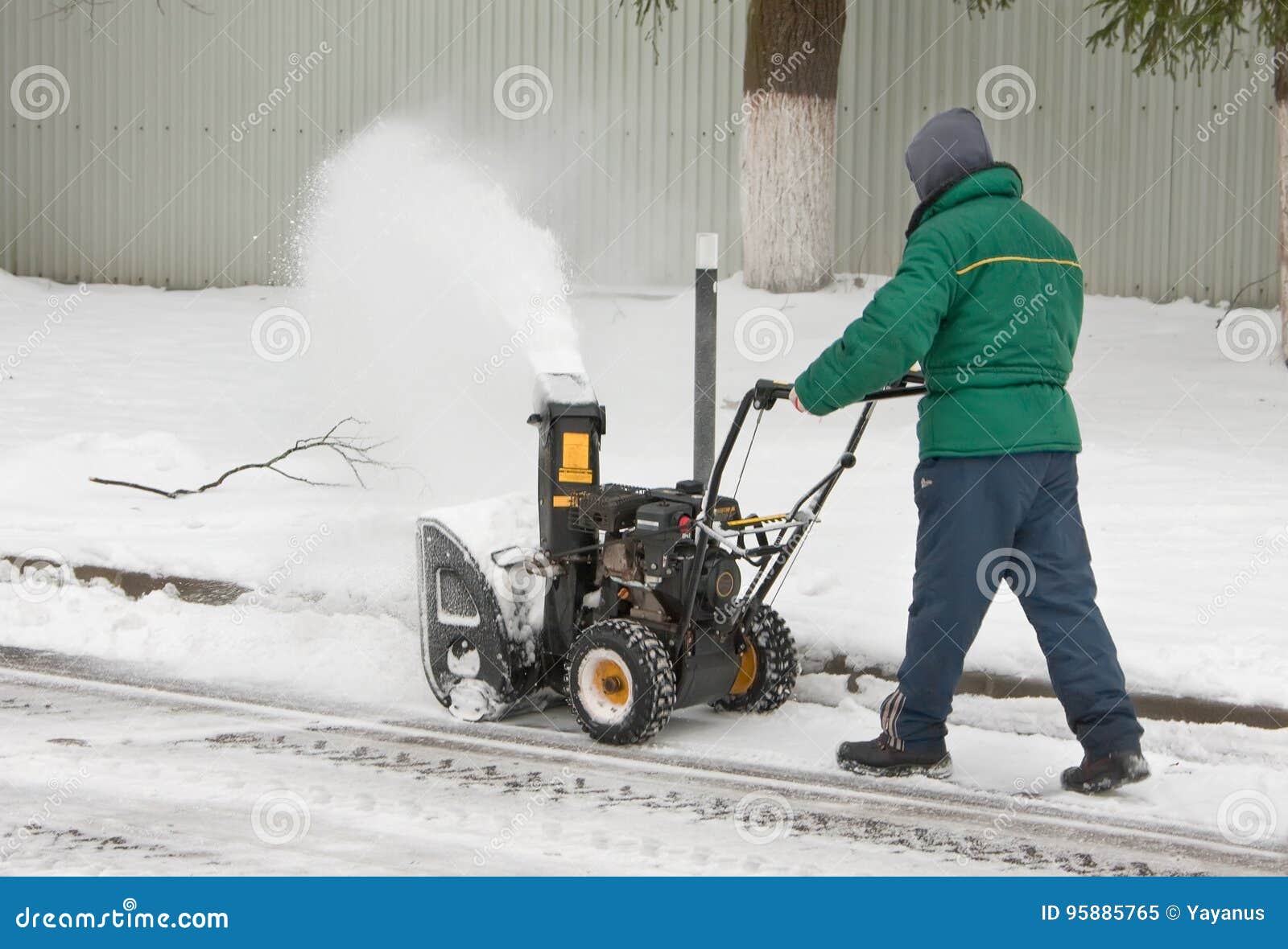 Man Removes Snow by Using a Snow Throwing Machine. Stock Image - Image ...