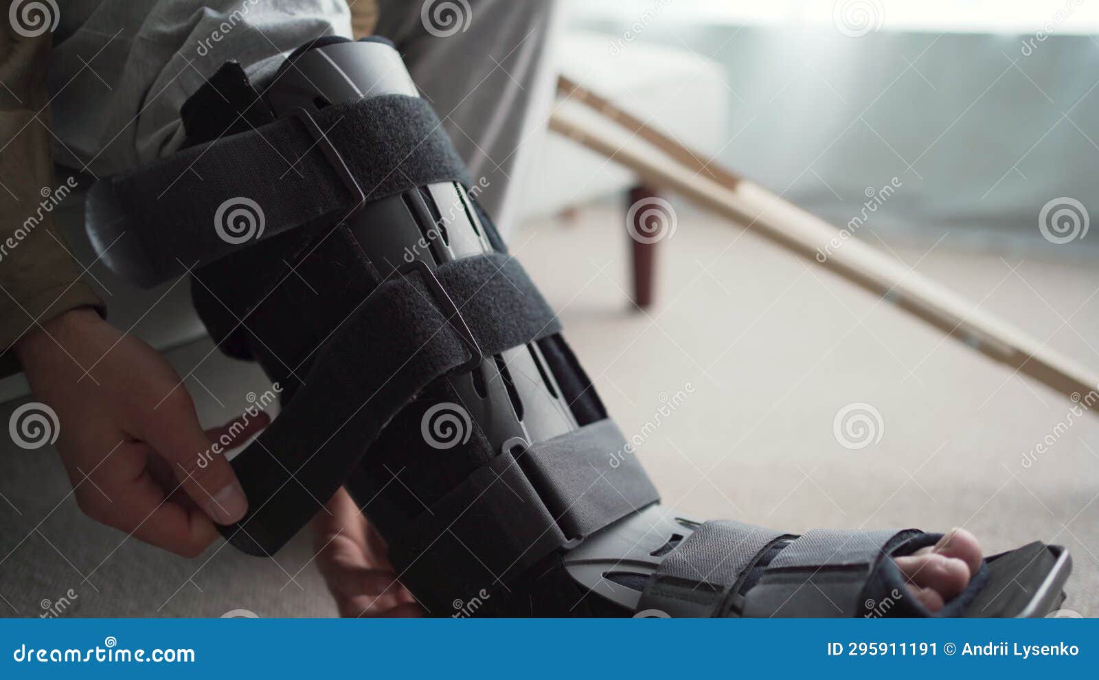 Man Removing Ankle Orthosis or Walker Boot on Leg Sitting on the Sofa ...