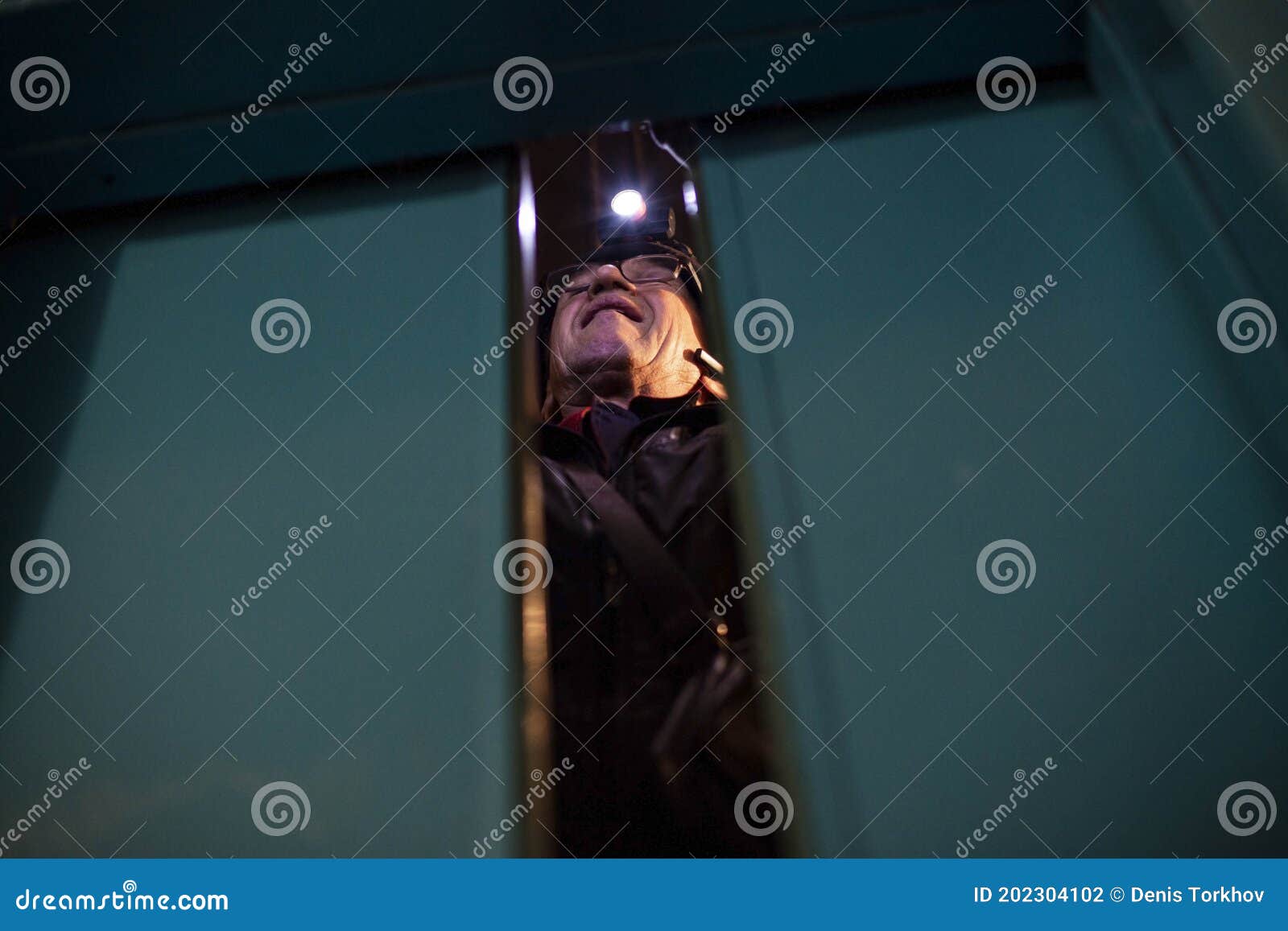 Man Repairing an Elevator at Night Inside a Shaft of a High-rise ...