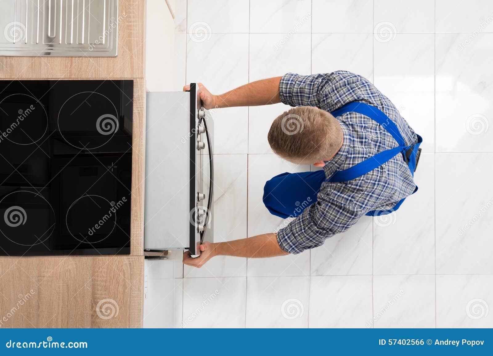 Man Repairing Kitchen Oven stock photo. Image of house - 57402566