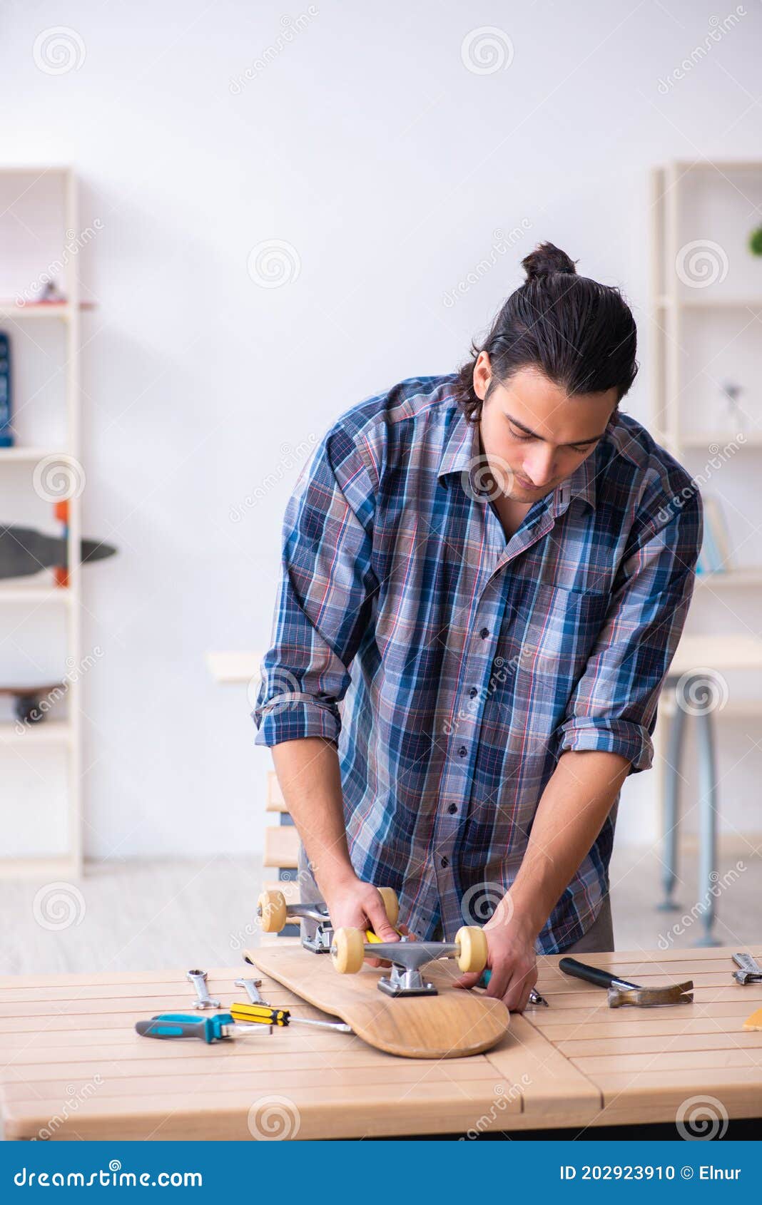 Young Man Repairing Skateboard at Workshop Stock Photo - Image of ...