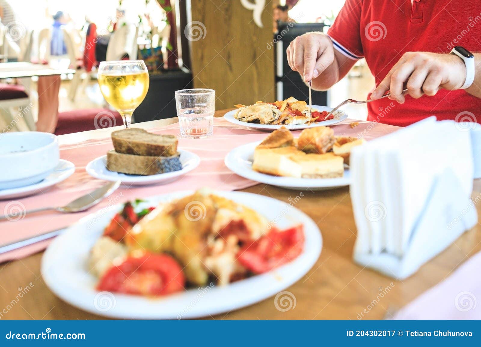The Man in the Restaurant is Eating. Holding a Fork and Knife Stock ...