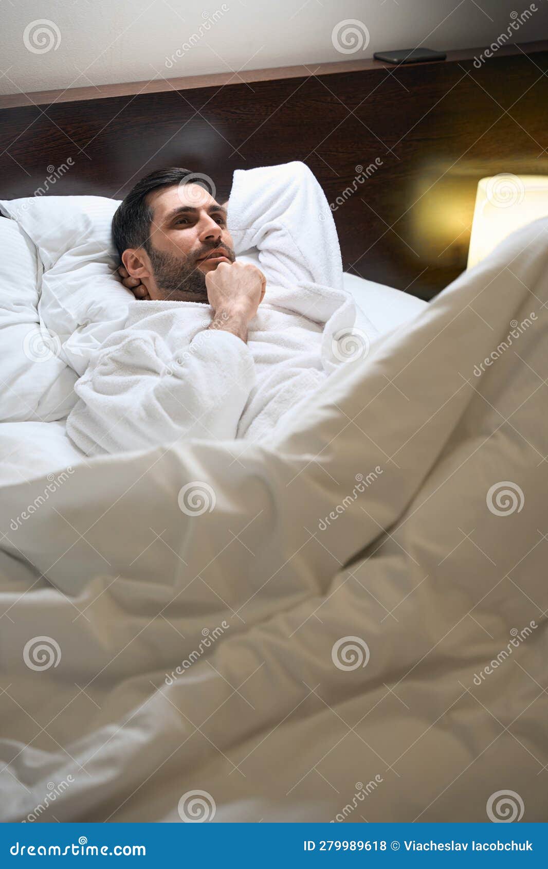 Man is Resting in Bed on Soft Pillows in Hotel Room Stock Photo - Image ...