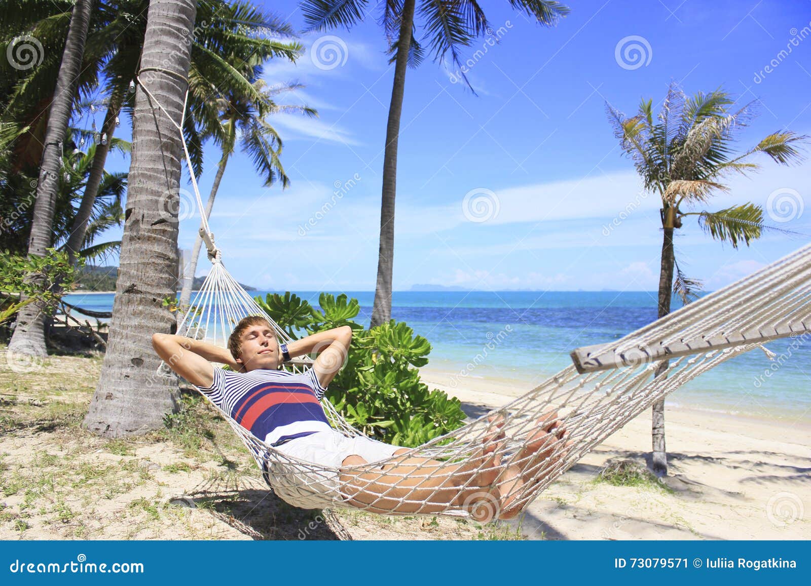 Man Resting in a Hammock Under the Palm Trees on the Beach with White ...