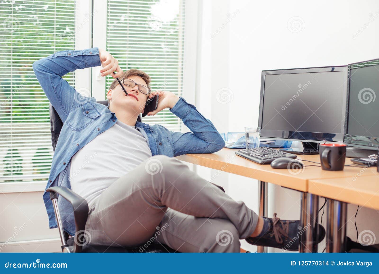 Man Resting and Talking on the Mobile Phone in the Office Stock Photo ...