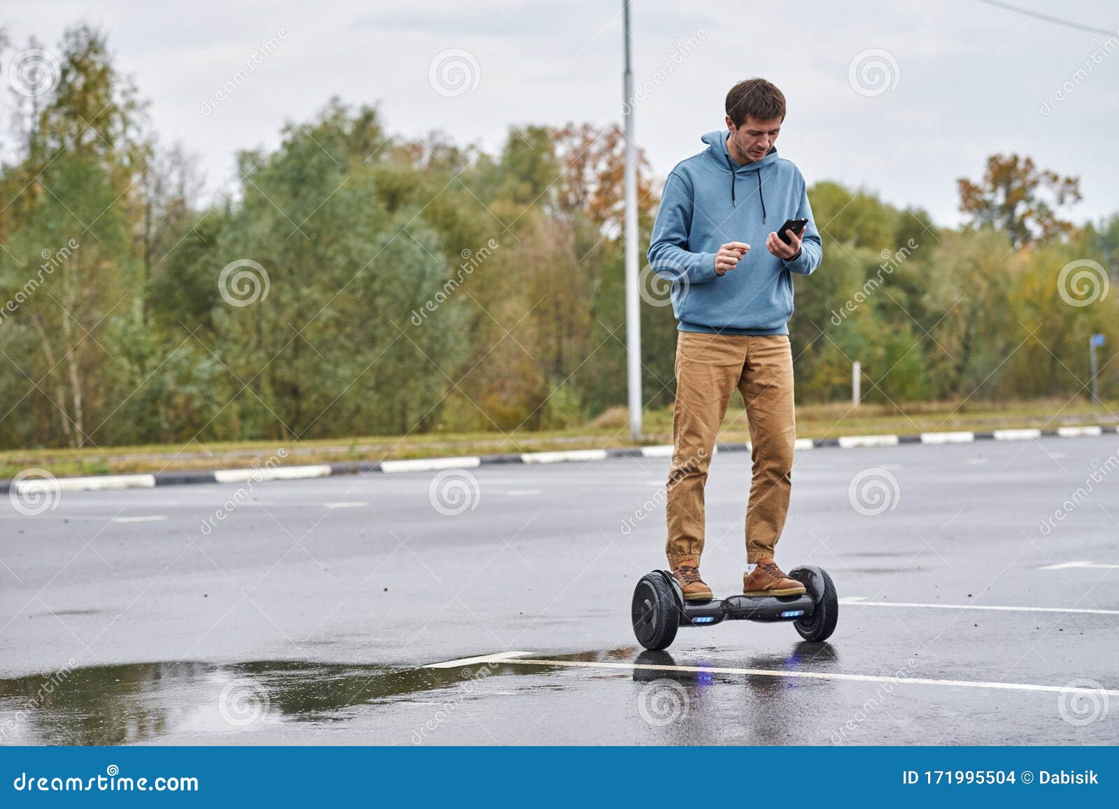 Man Riding on the Hoverboard and Using Smartphone Outdoor Editorial ...