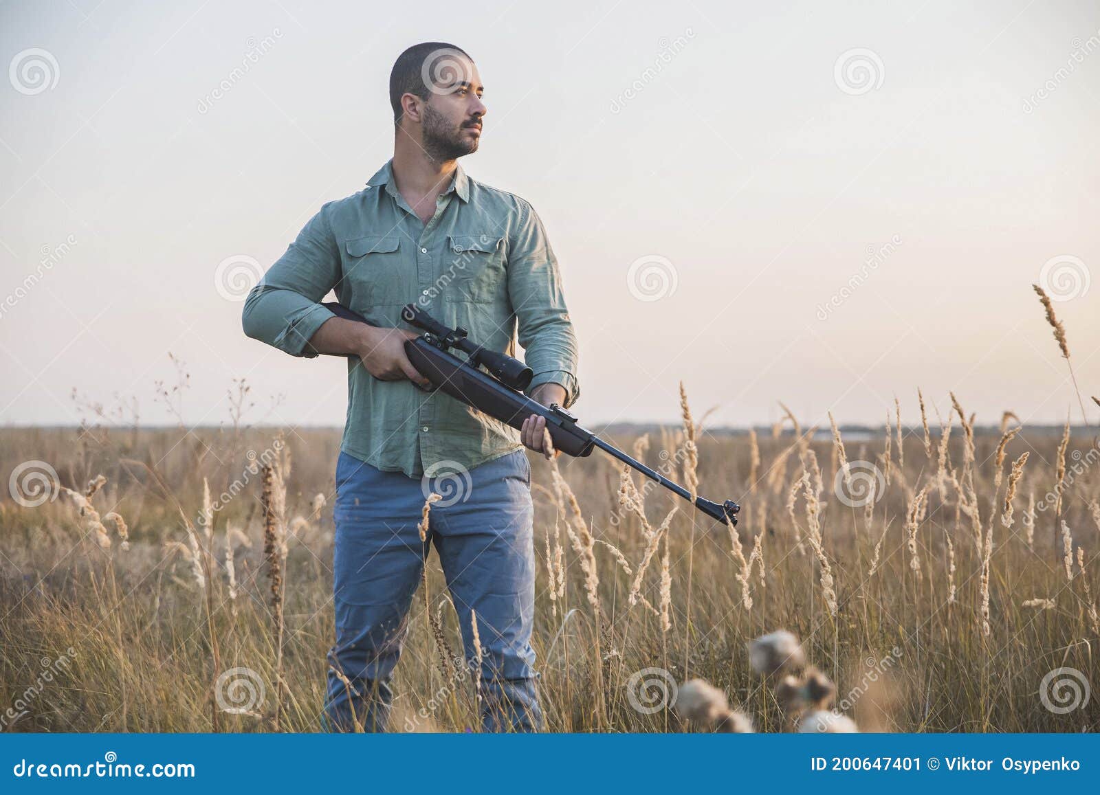 Man with a Rifle with a Telescopic Sight Stands in a Field Stock Image ...
