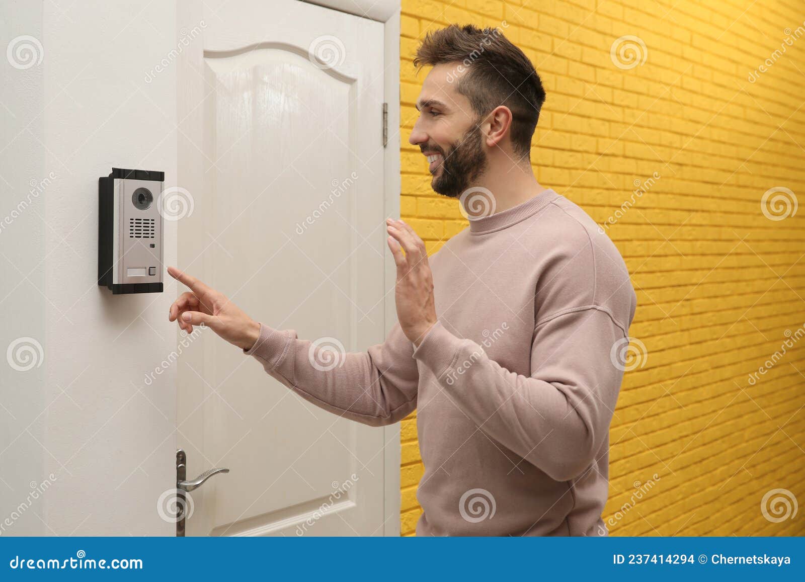 Happy Man Ringing Intercom while Waving To Camera in Entryway Stock ...