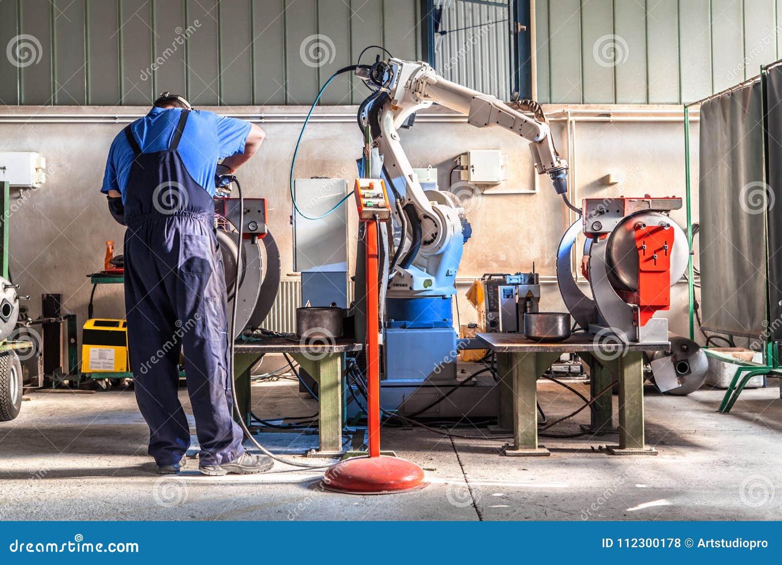 Man and Robotic Machine Work Together Inside Industrial Building. Stock ...