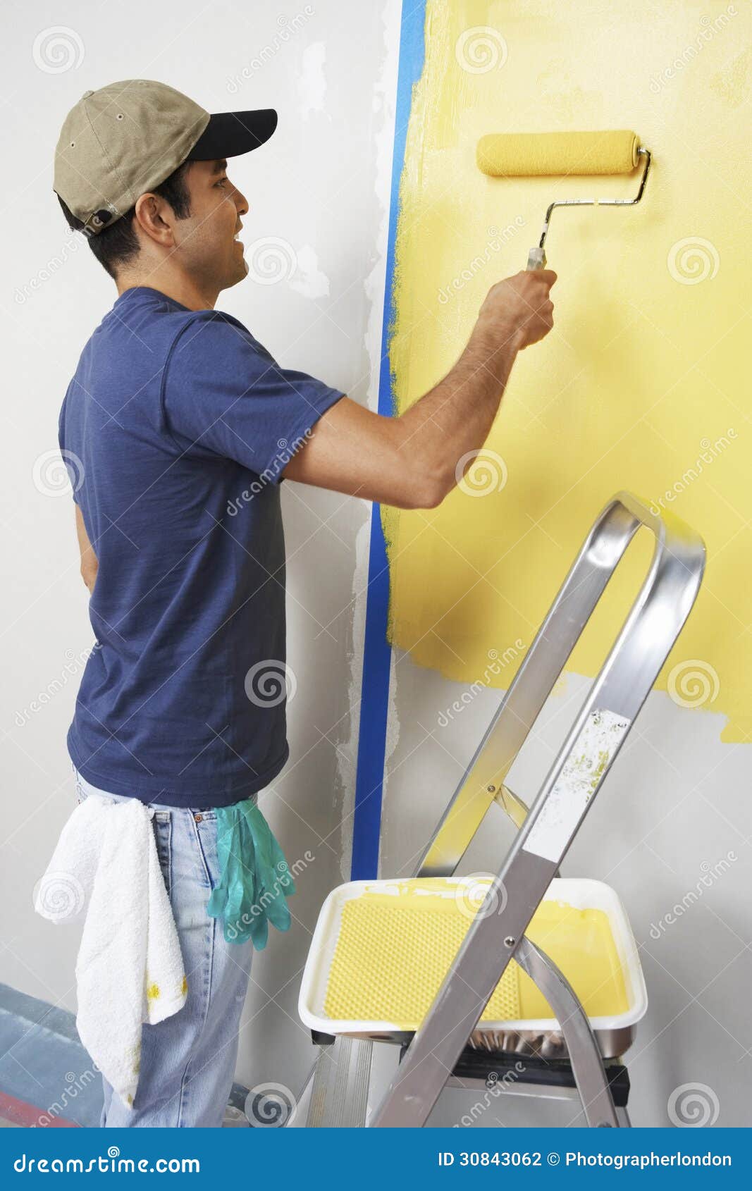 Man with Roller Applying Yellow Paint on a Wall Stock Photo - Image of ...
