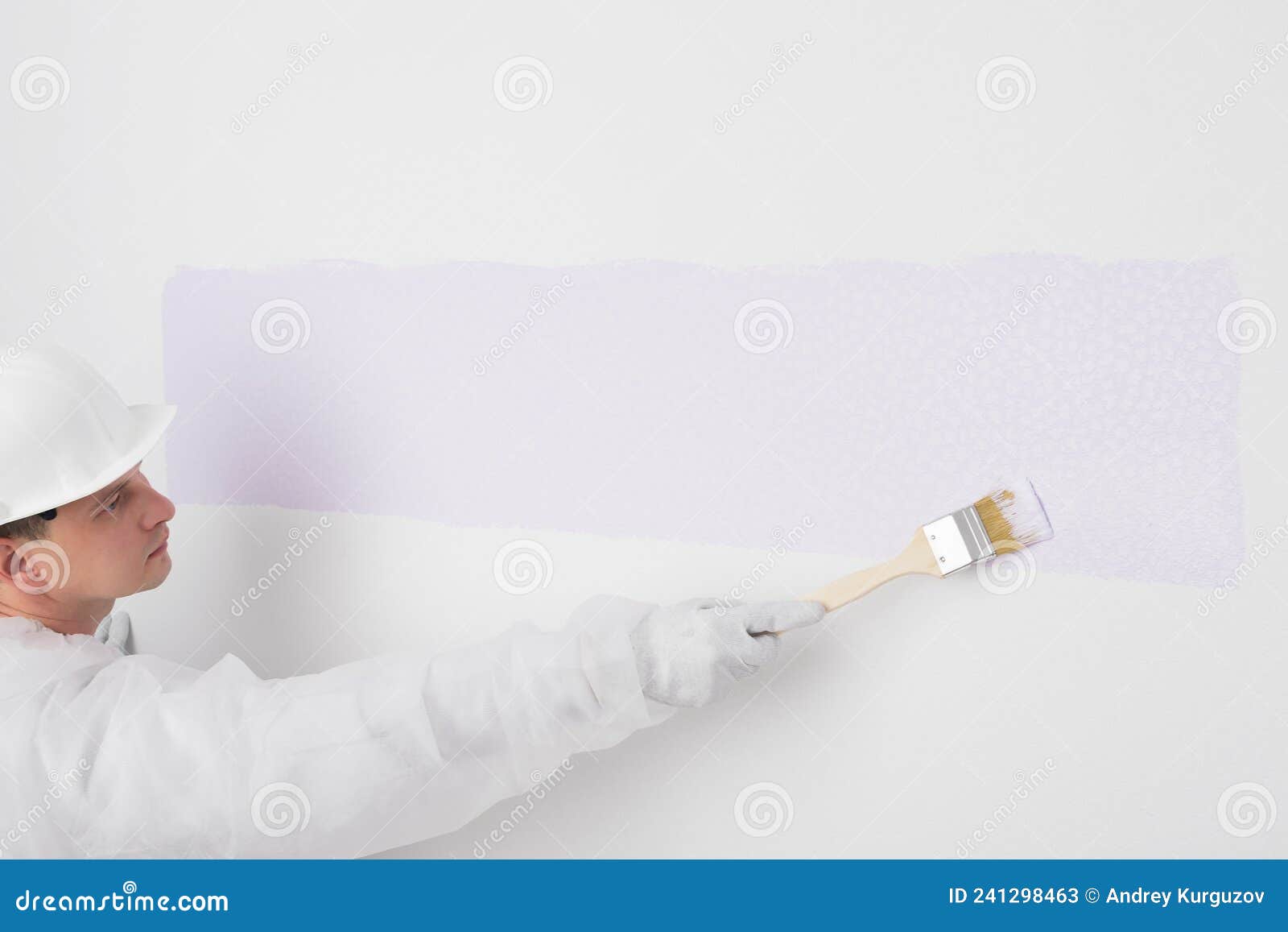 A Man with a Roller Starts Painting a White Wall in a Different Color ...