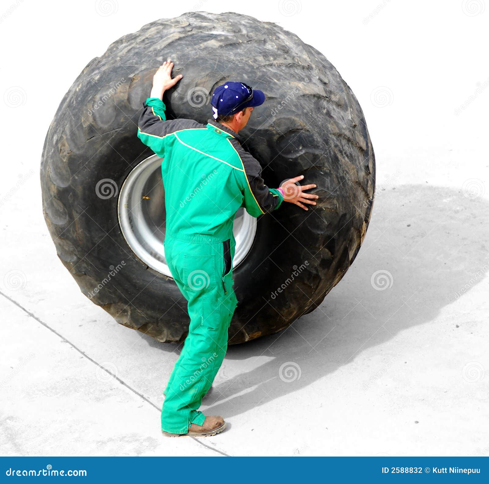 Man Rolling Huge Truck Wheel Stock Photo - Image of large, wheel: 2588832