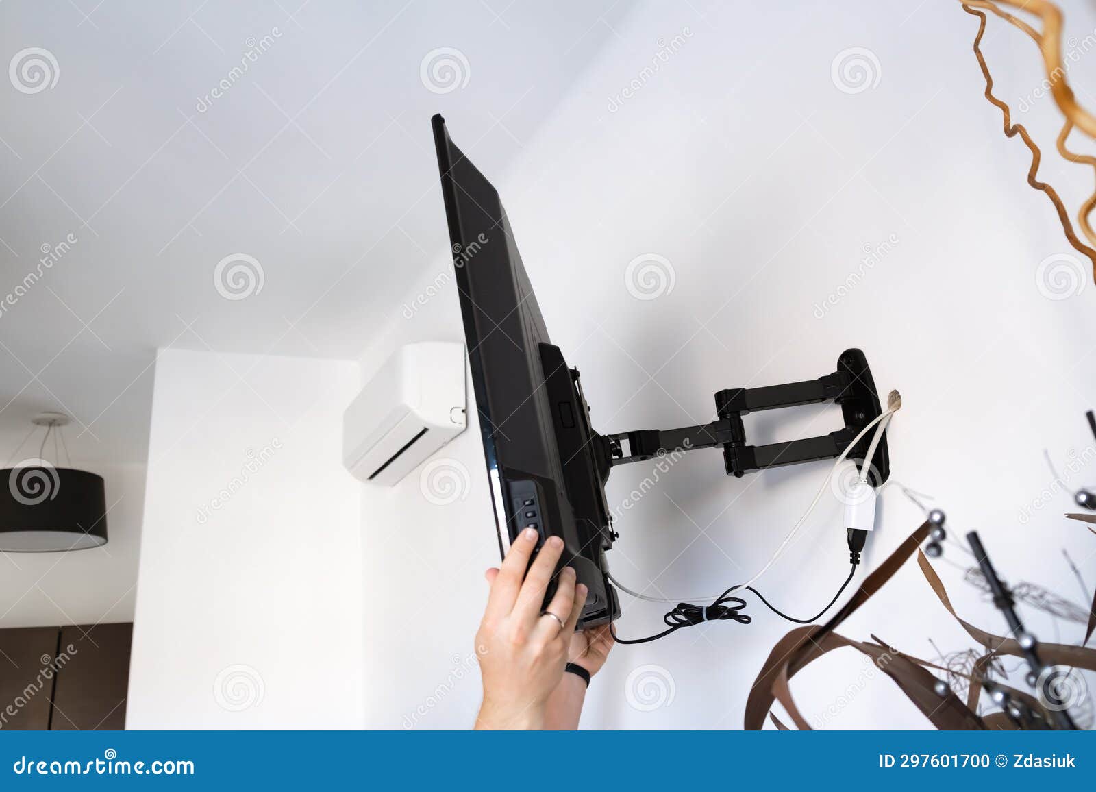 A Man Rotates a Flat-screen TV Hanging on a Bracket, Demonstrating a ...