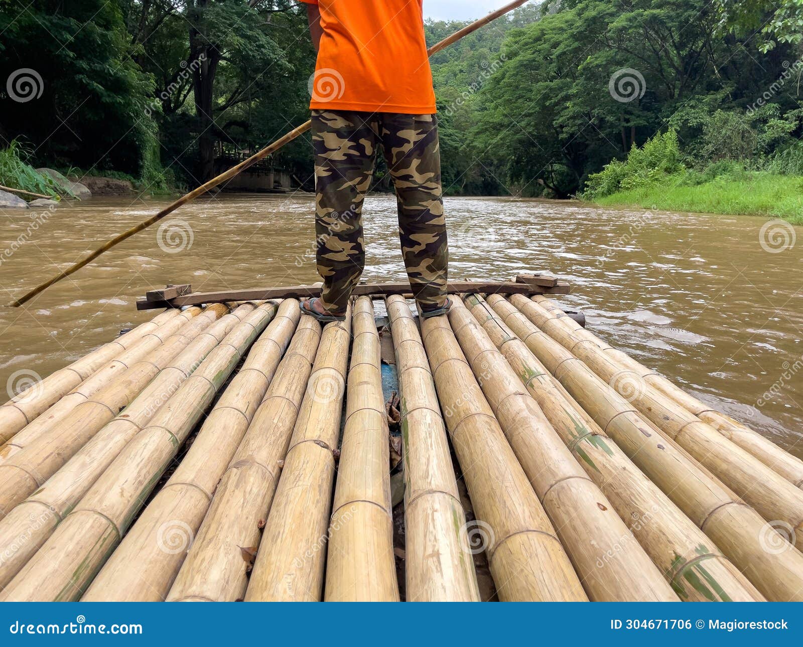 Man Rowing Bamboo Raft. Man Uses a Bamboo To Push a Raft on a River and ...