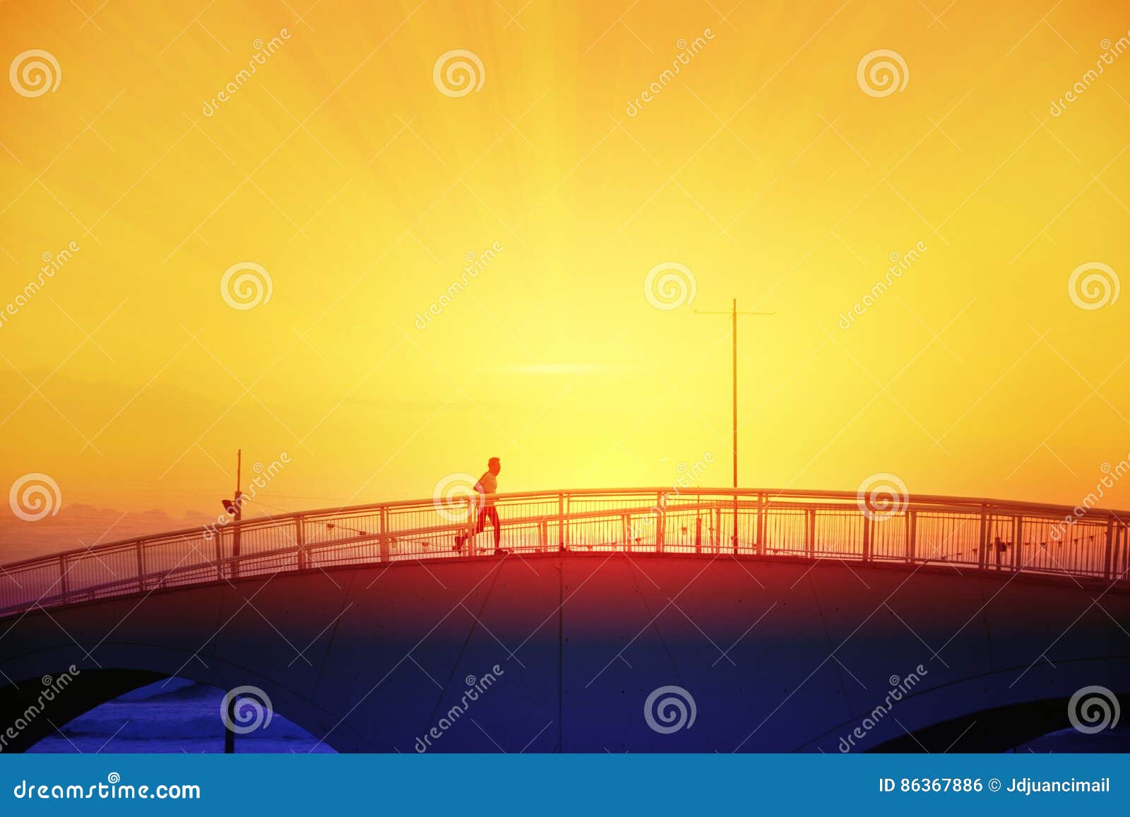 Man Running Crossing a Bridge Next To the Beack at Sunset. Stock Photo ...