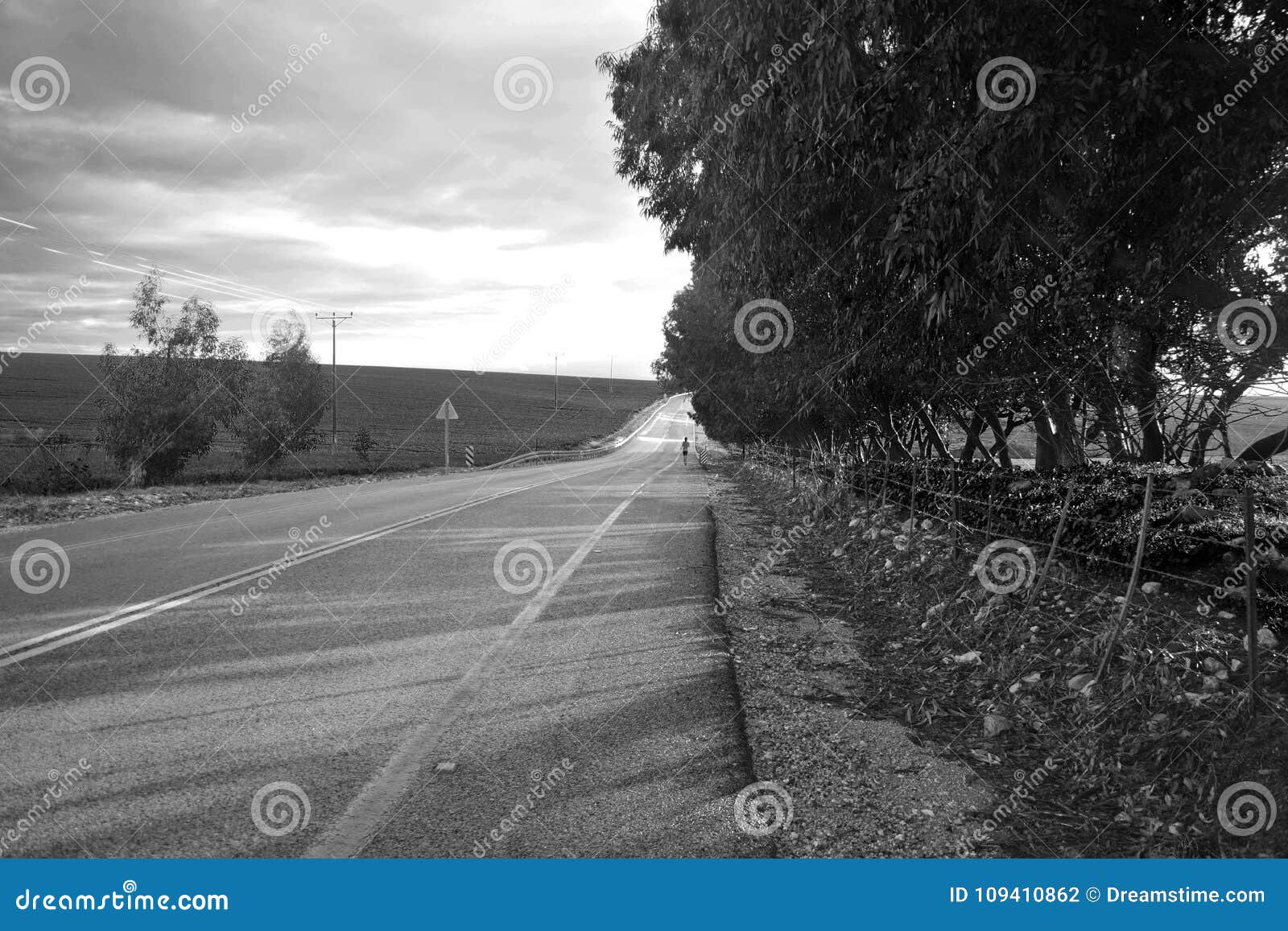 A Man is Running on an Empty Road Stock Photo - Image of trees, clouds ...