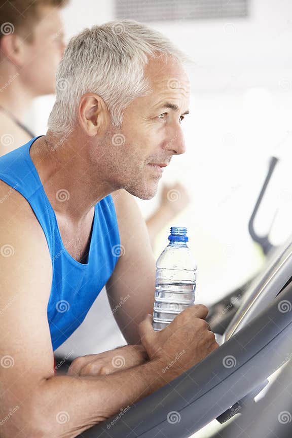 Man on Running Machine in Gym Drinking Water Stock Photo - Image of ...