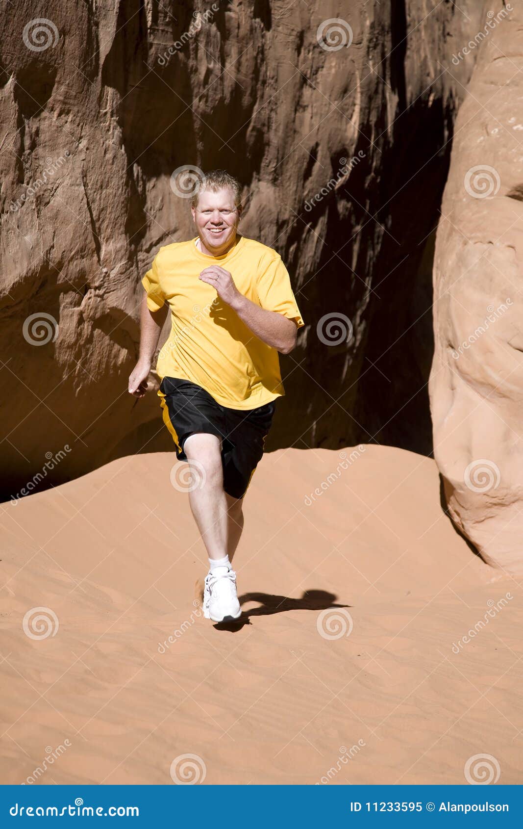 Man Running in Sand with Yellow Shirt Stock Image - Image of rock, sand ...