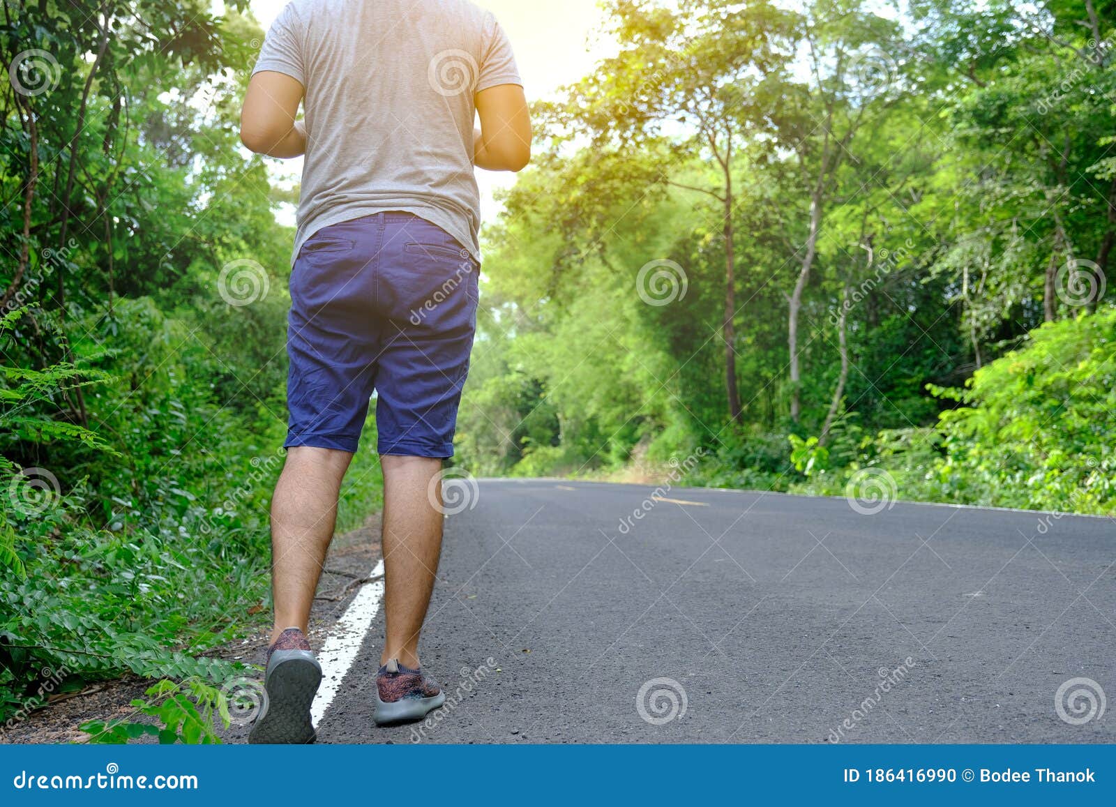 The only Man Running on the Side of the Road Surrounded by Trees Stock ...