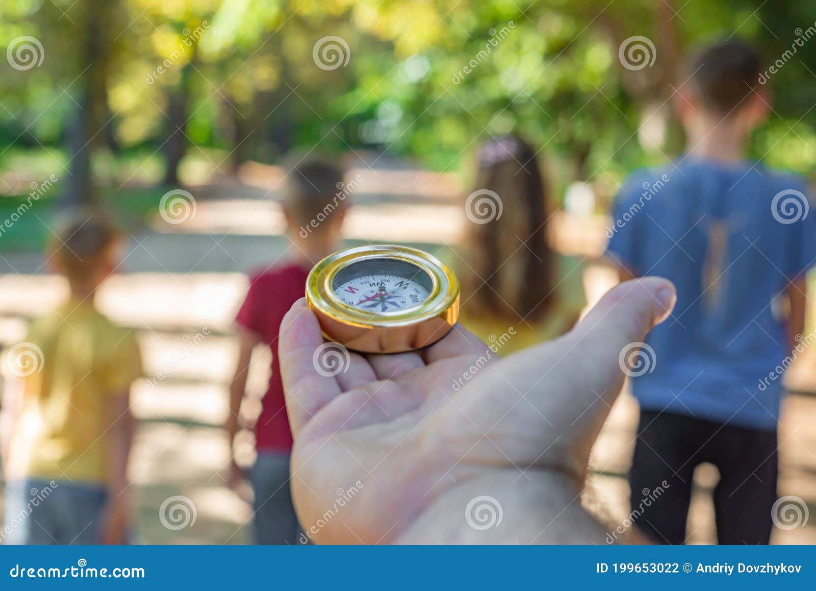 A Man`s Hand with a Compass, Children are Standing in Front of Him and ...
