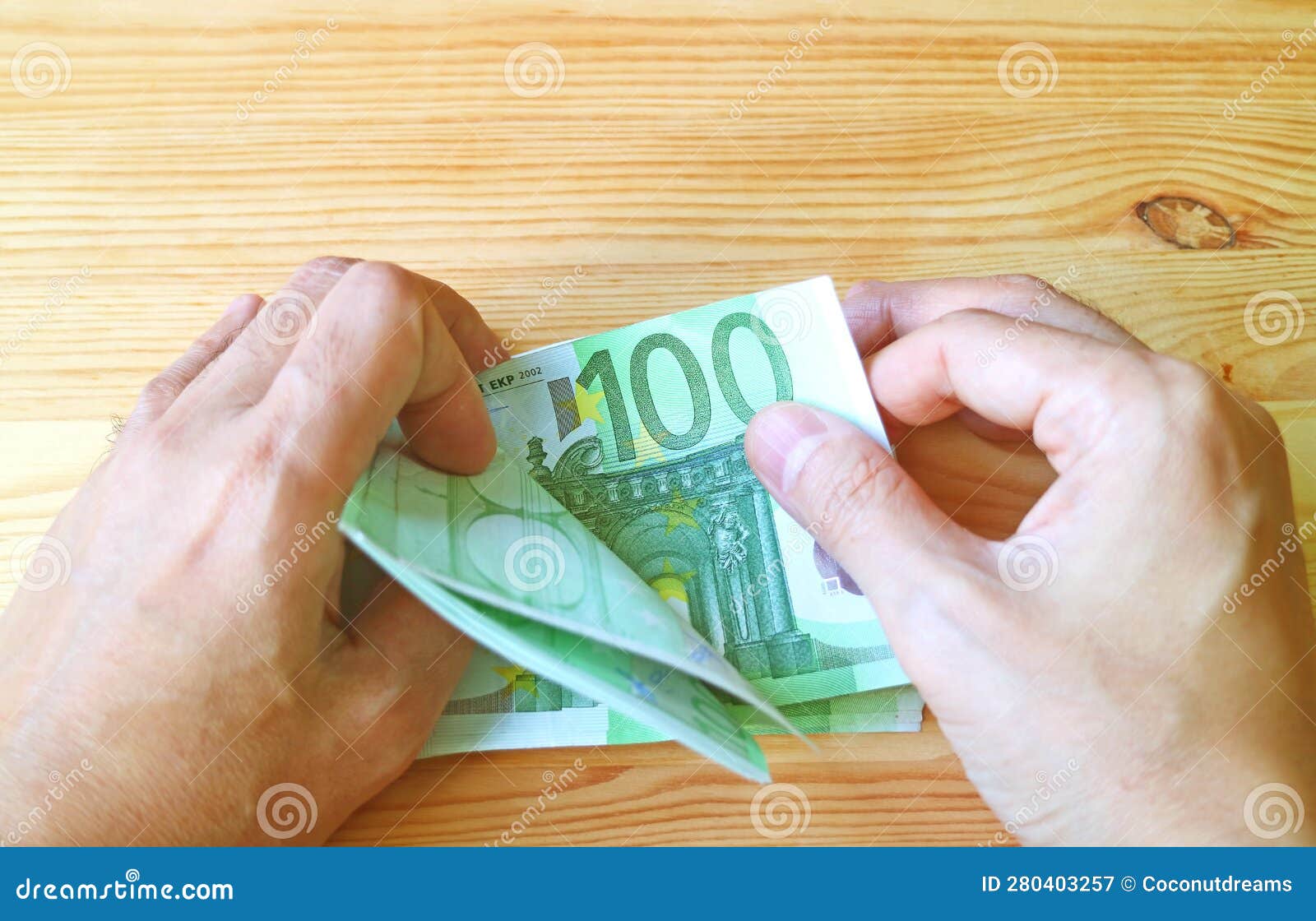 Hand Holding a Bundle of 100 EURO Banknotes on Wooden Backdrop Stock ...