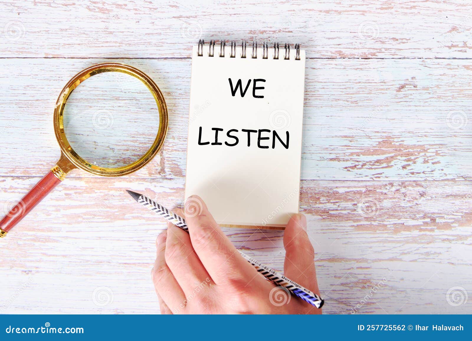 A Man S Hand Holds a Notebook with the Inscription we Listen Stock ...