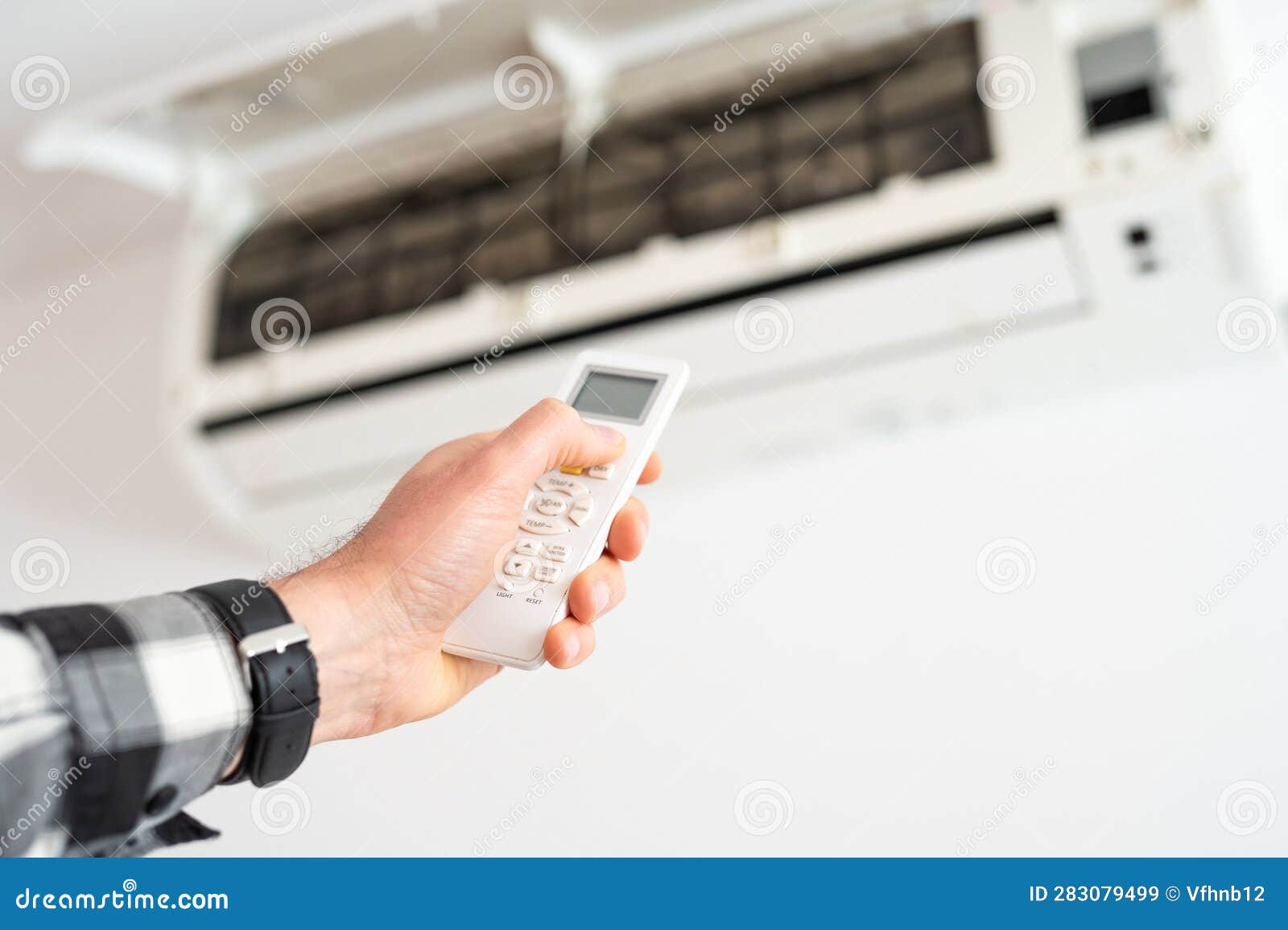 A Man& X27;s Hand Holds a Remote Control from an Air Conditioner with a ...