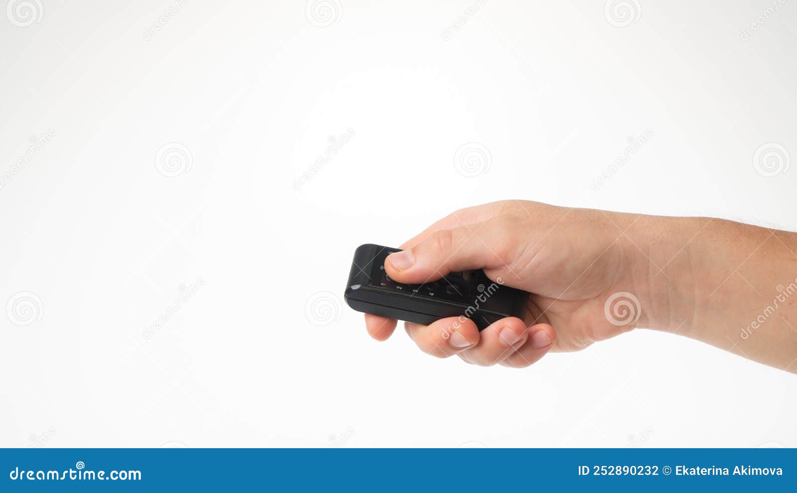 A Man& X27;s Hand Holds a Small Remote Control on a White Background ...
