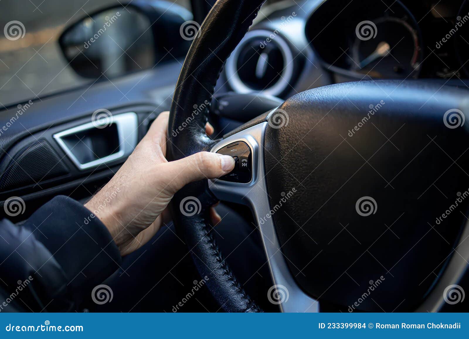 A Man`s Hand Holds the Steering Wheel of the Car and Controls the Multi ...