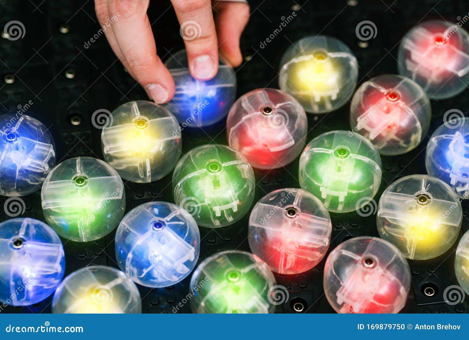 A Man`s Hand Inserts a Lamp into an Electrical Panel. Colored Light ...